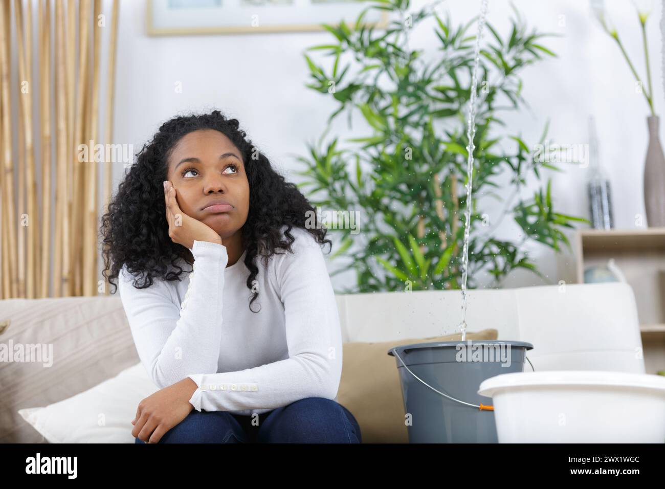 frustrated woman looking a leak from ceiling Stock Photo - Alamy