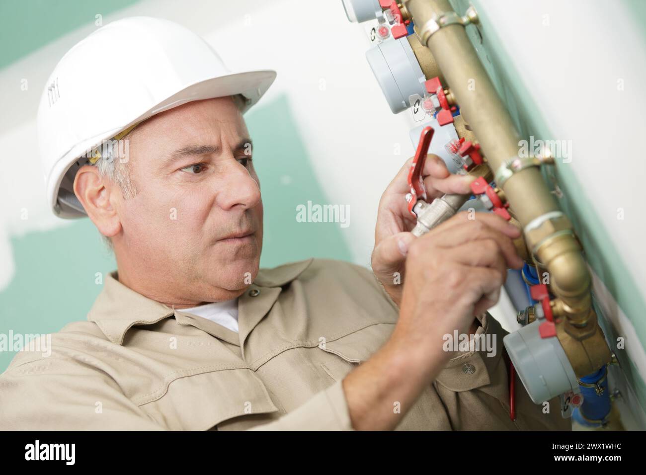 plumber at work installing a water meter Stock Photo - Alamy