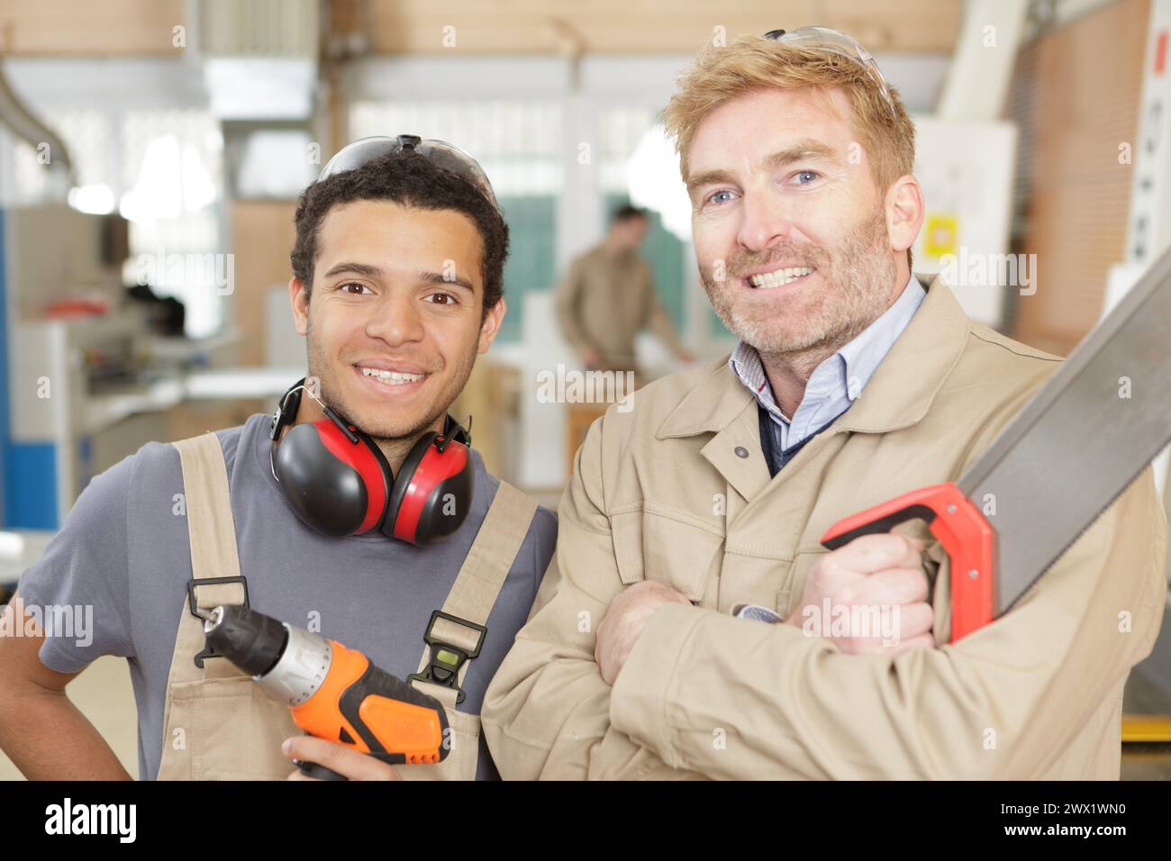 portrait of carpenter with apprentice holding tools Stock Photo - Alamy