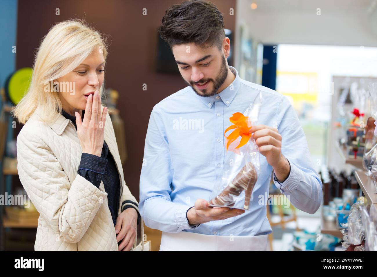 customers choosing chocolate in shelf Stock Photo - Alamy