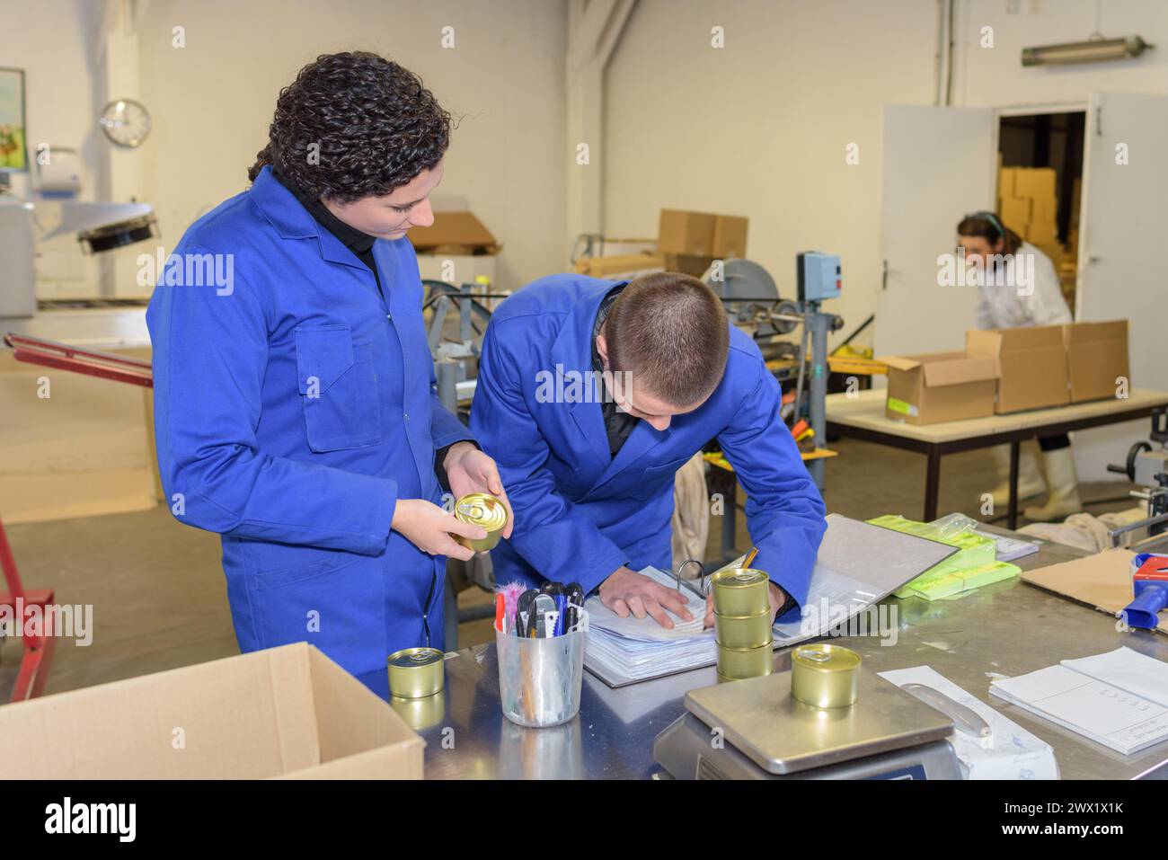 factory workers checking product weights on scales Stock Photo - Alamy