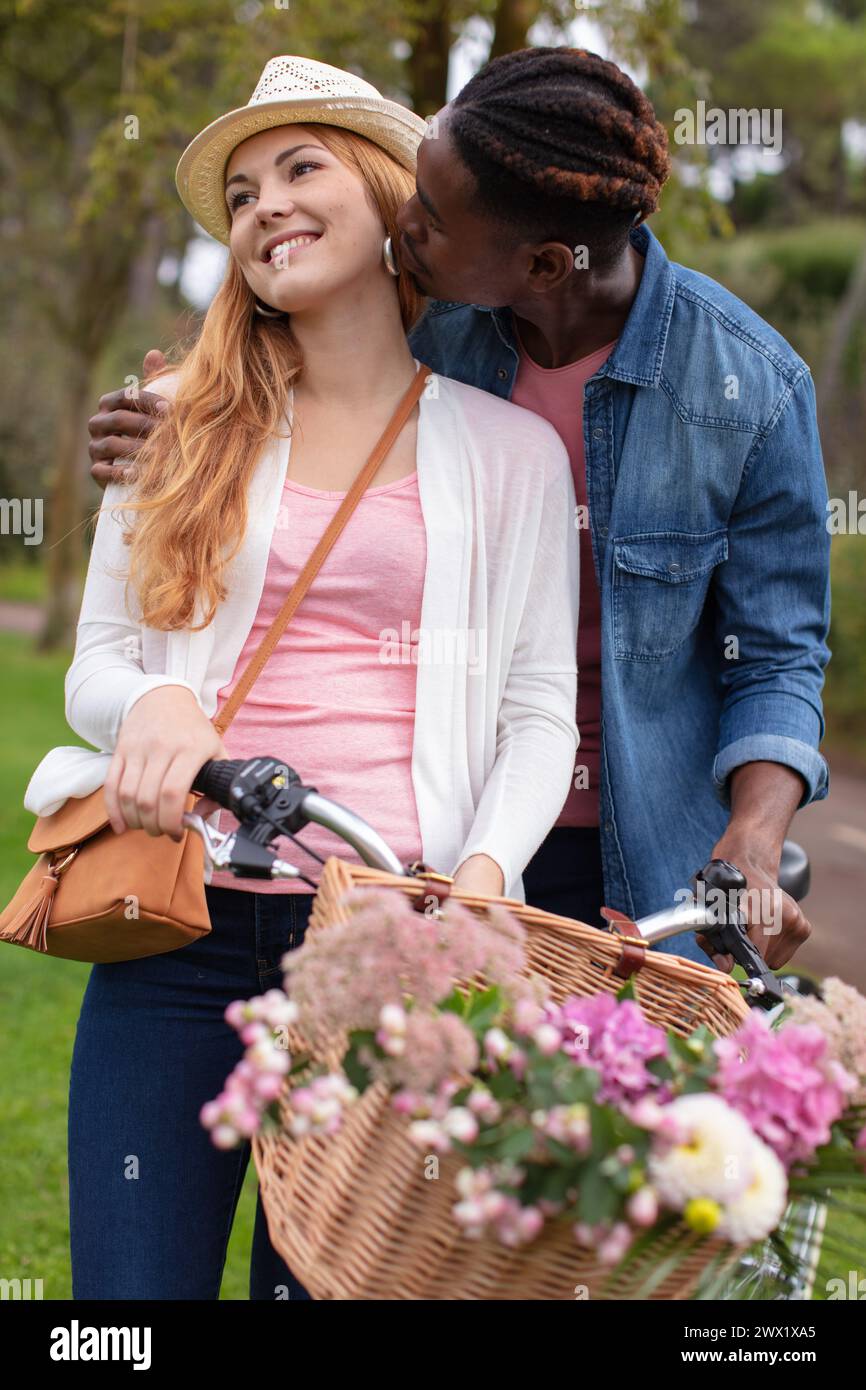 couple stops riding bike with flowers for a kiss Stock Photo - Alamy