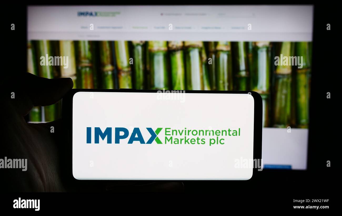 Person holding cellphone with logo of British investment company Impax Environmental Markets plc ...