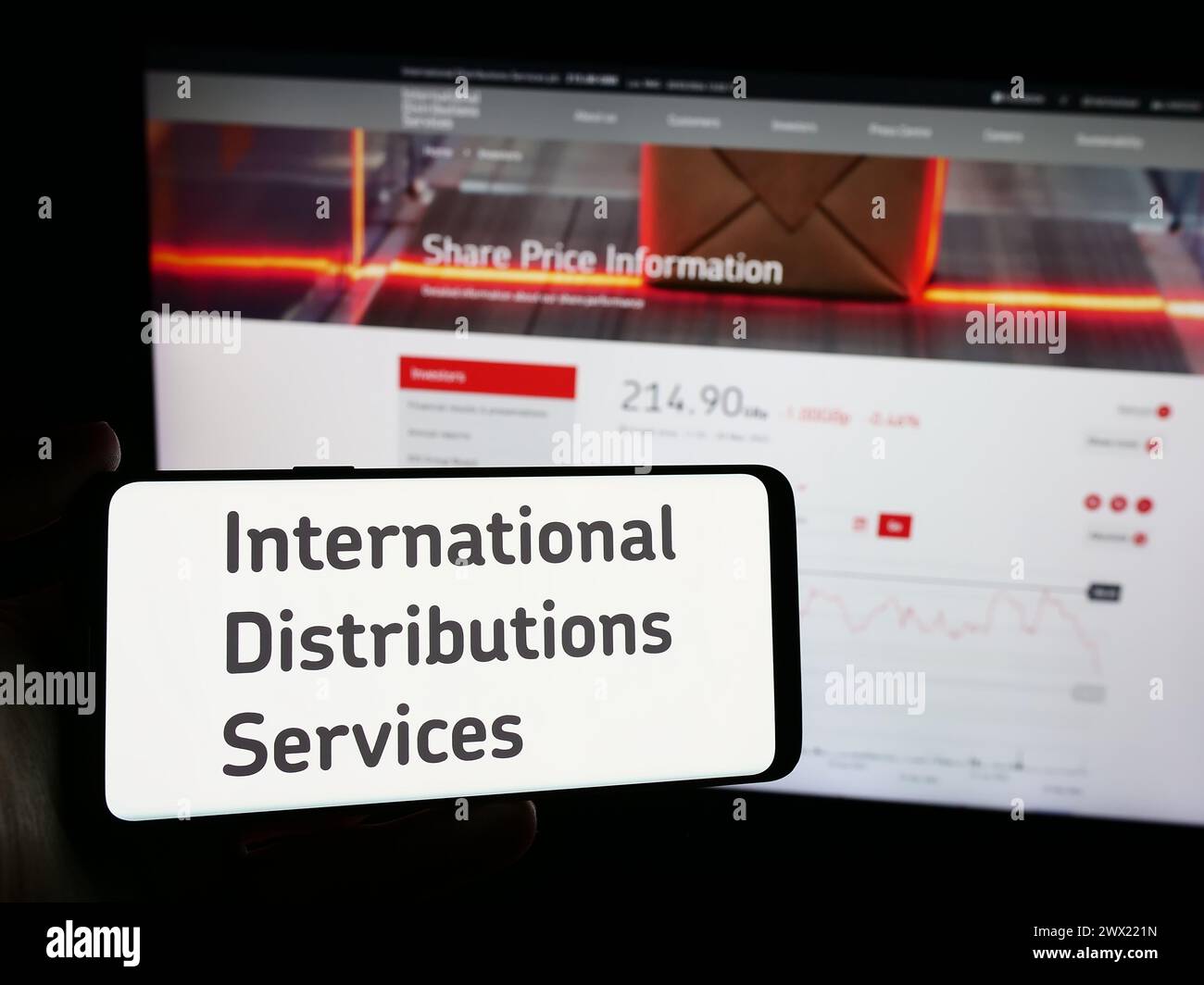 Person holding mobile phone with logo of British company International ...