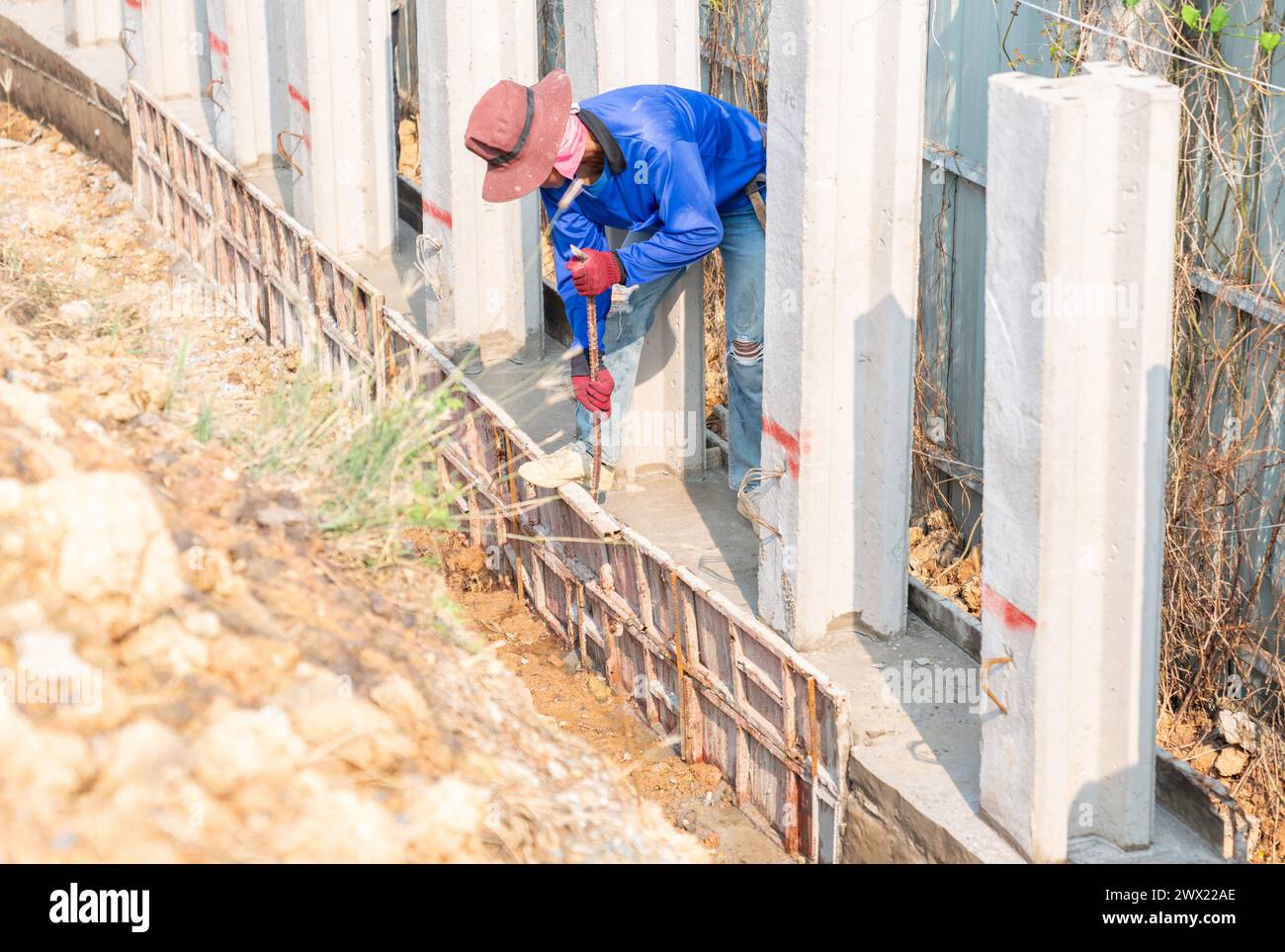 Worker removing concrete formwork of beam retaining walls in ...