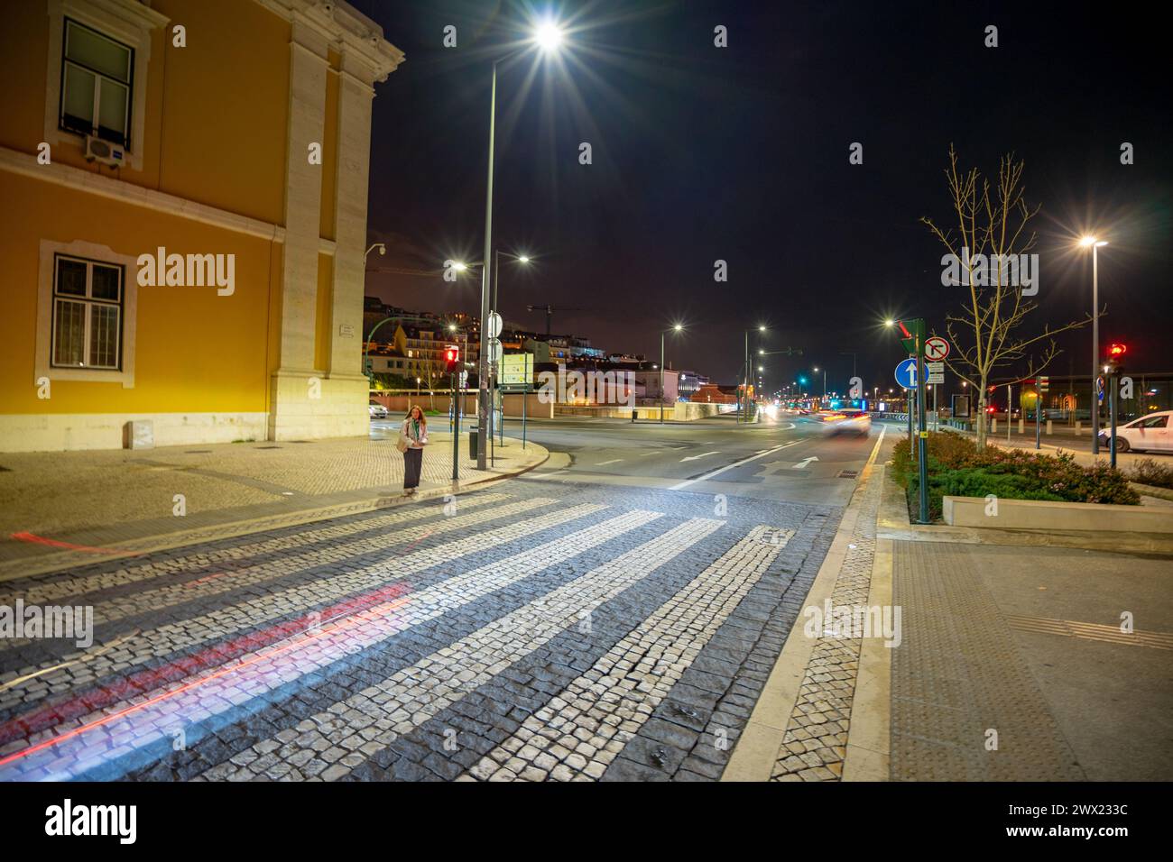 Night image with trailing car lights at pedestrian crossings on the ...