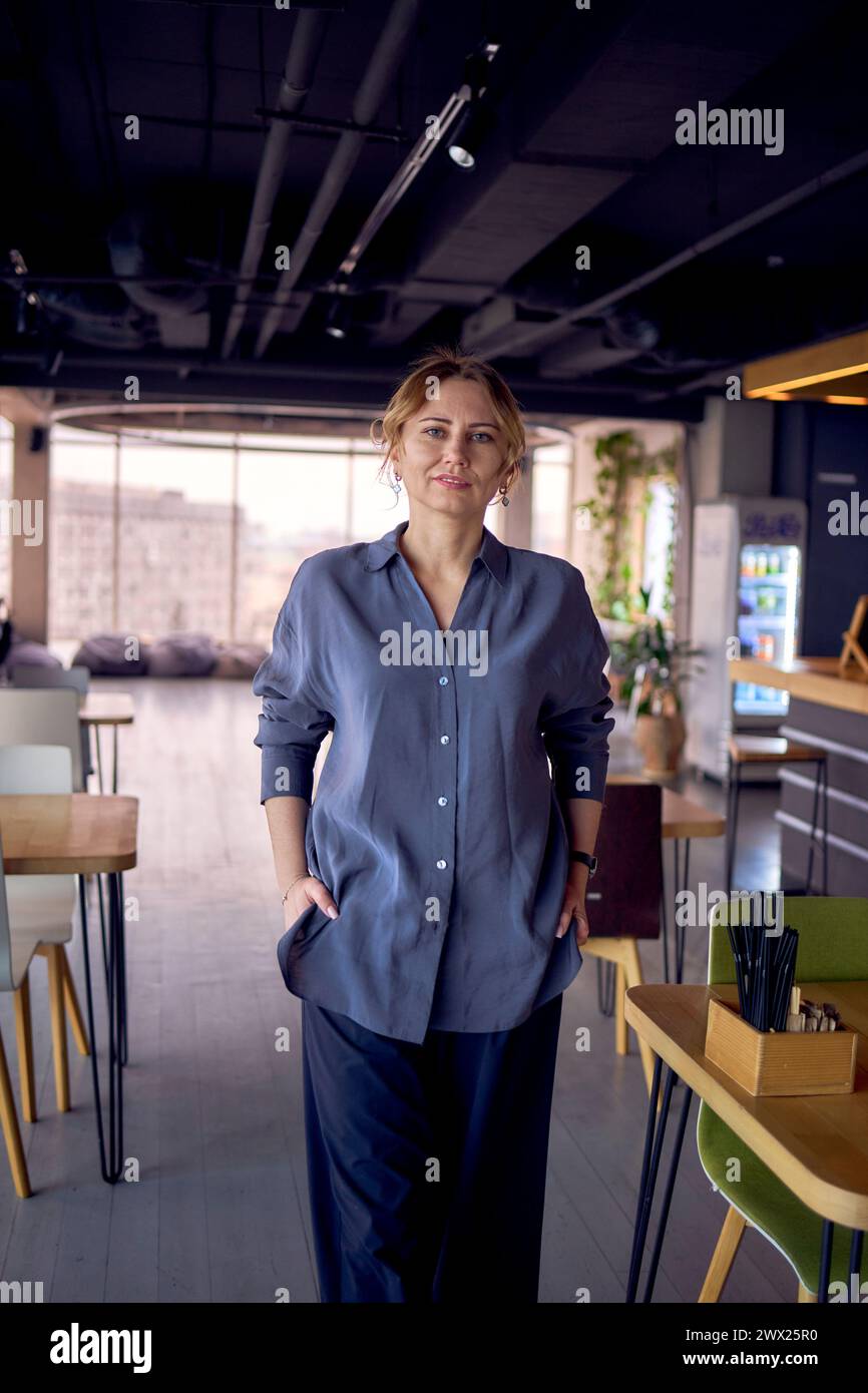 attractive middle age woman walks in a modern coworking neutral design ...