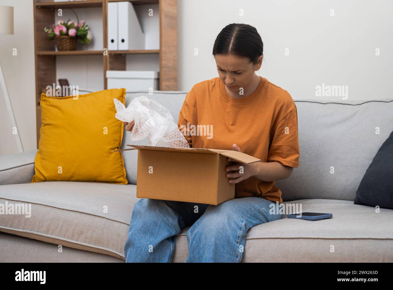 Dissatisfied woman finds defect in goods in box with filling for safety ...