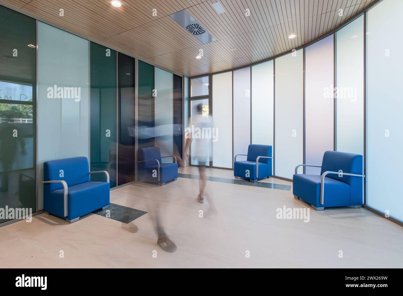 People walking on clinic, hospital waiting room. Long exposure shot of ...