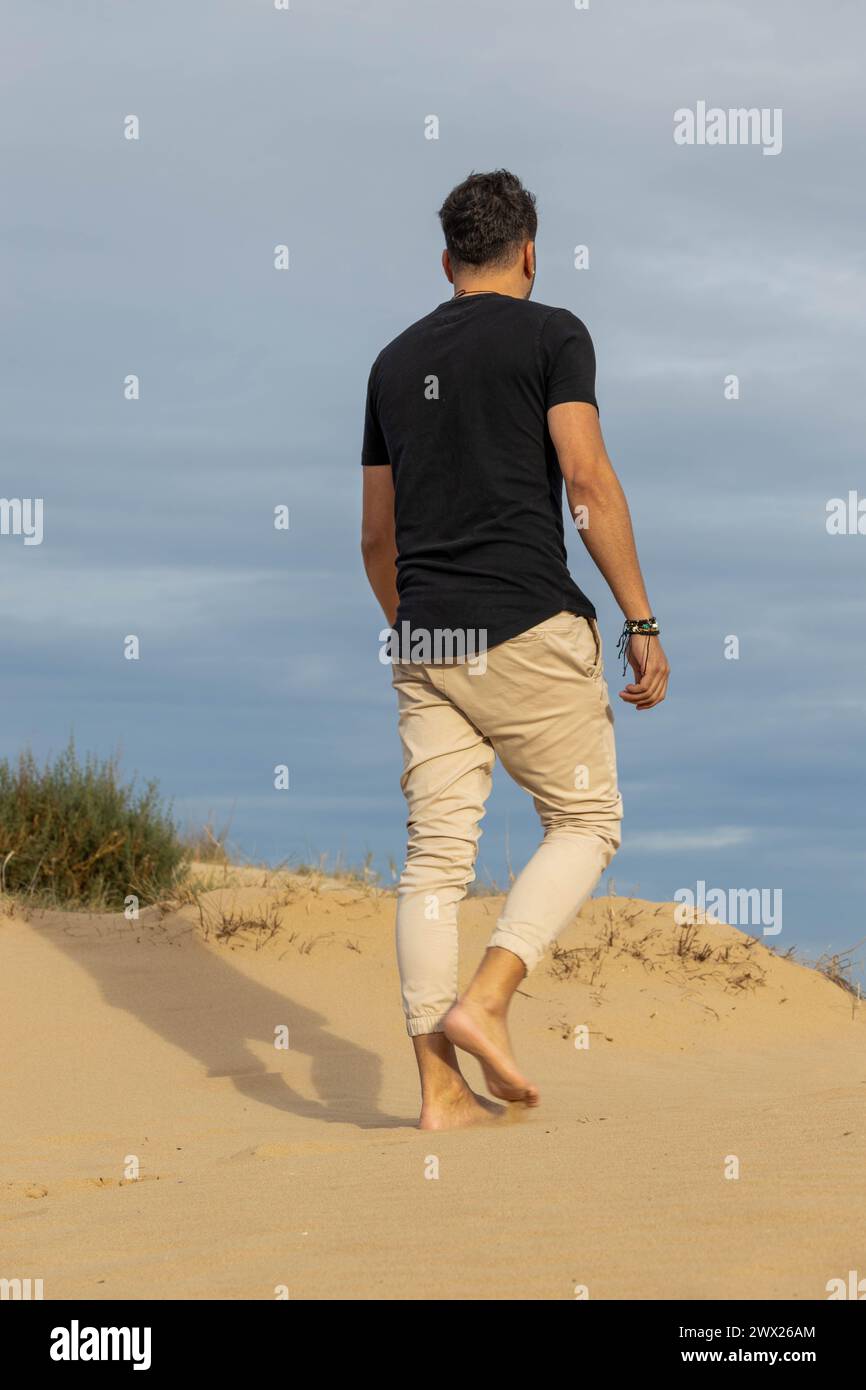 Barefoot man walking on the beach in the desert Stock Photo - Alamy