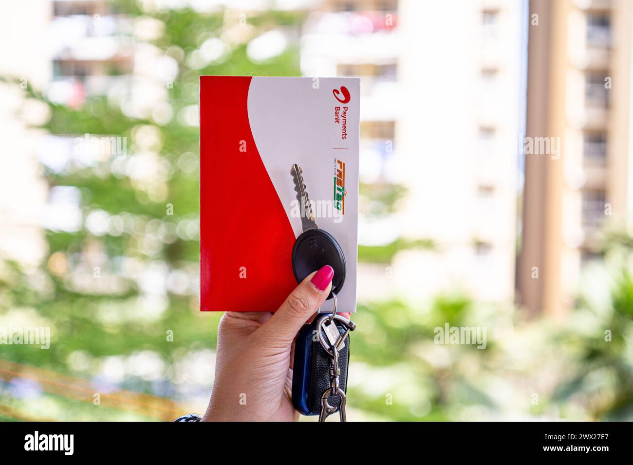 Woman holding Airtel Payment bank Fastag with car key showing the new ...