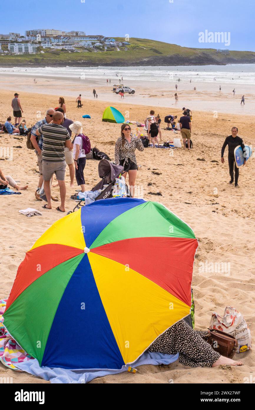 Holidaymakers and colourful umbrellas and windbreaks on a busy Fistral ...