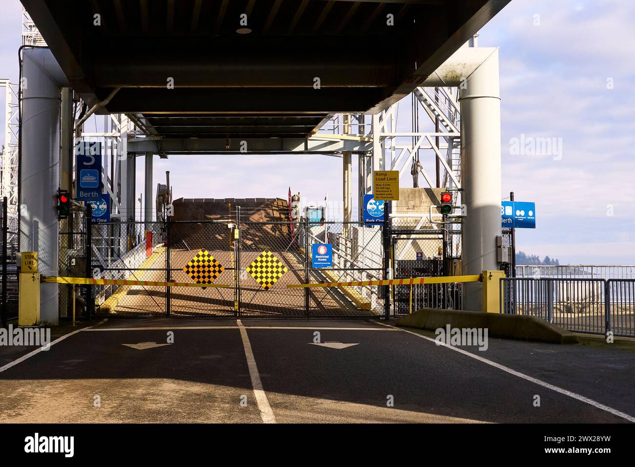 A road leading to an empty ferry loading ramp on a sunny day Stock ...
