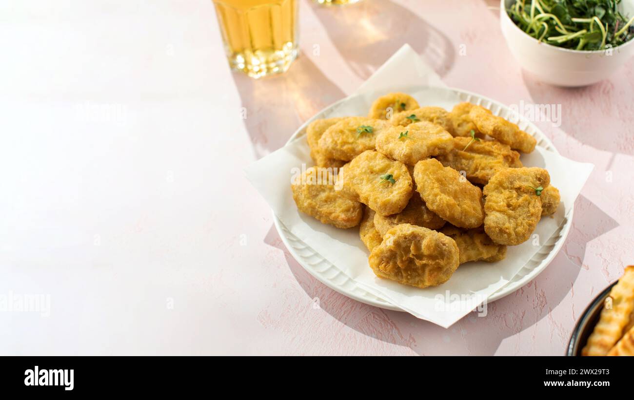 Delicious golden chicken nuggets on a plate on the table. Fast food ...