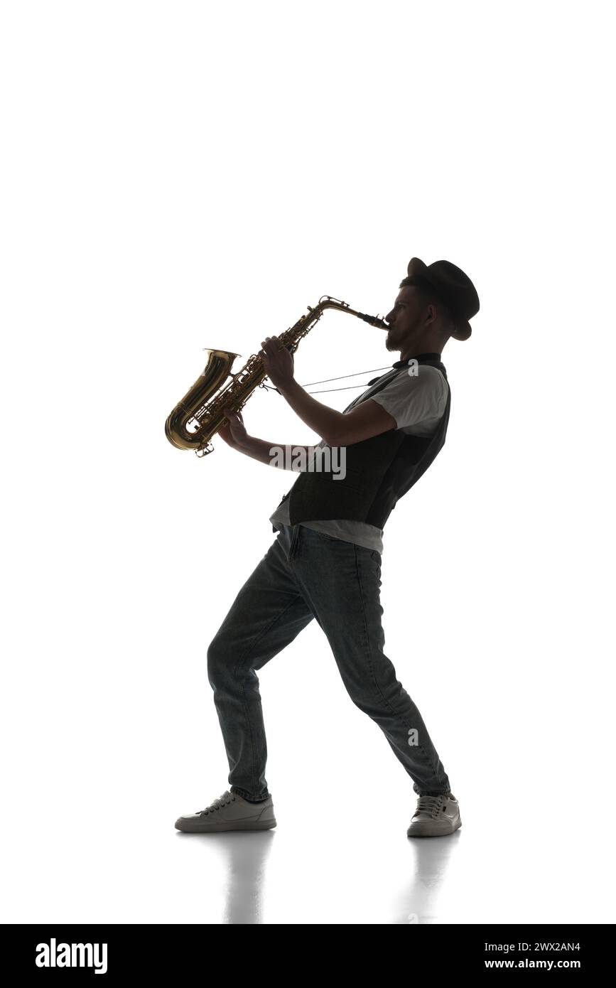 Talented young man making creative performance, playing saxophone ...