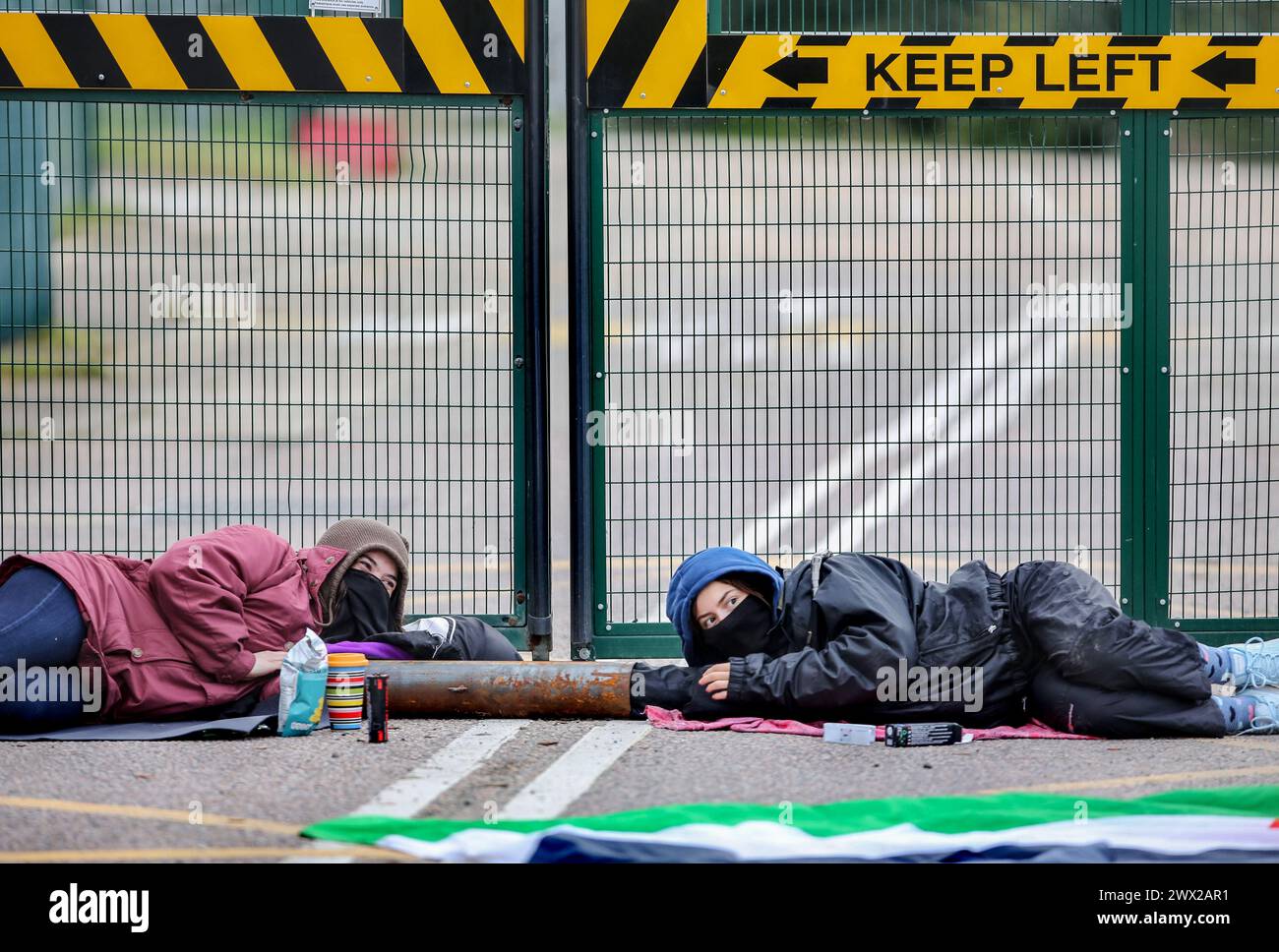 Activists from Palestine Action lay on the ground blocking gate access ...