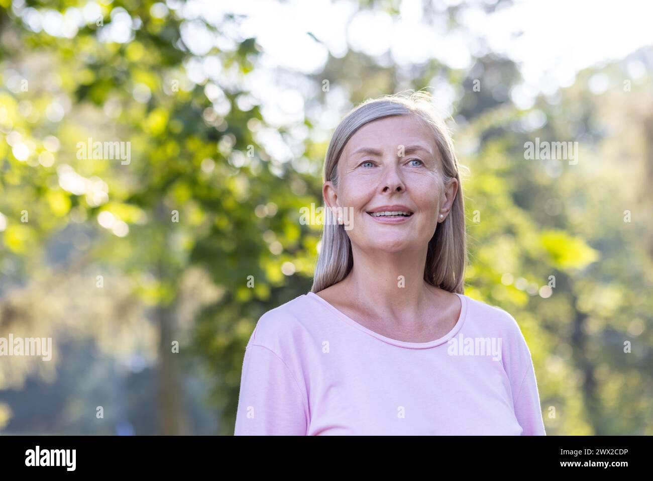 Close-up photo of a gray-haired senior woman walking in the park ...