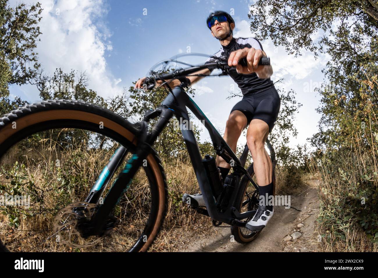 low side view of a mountain biker in full action with his mountain bike ...