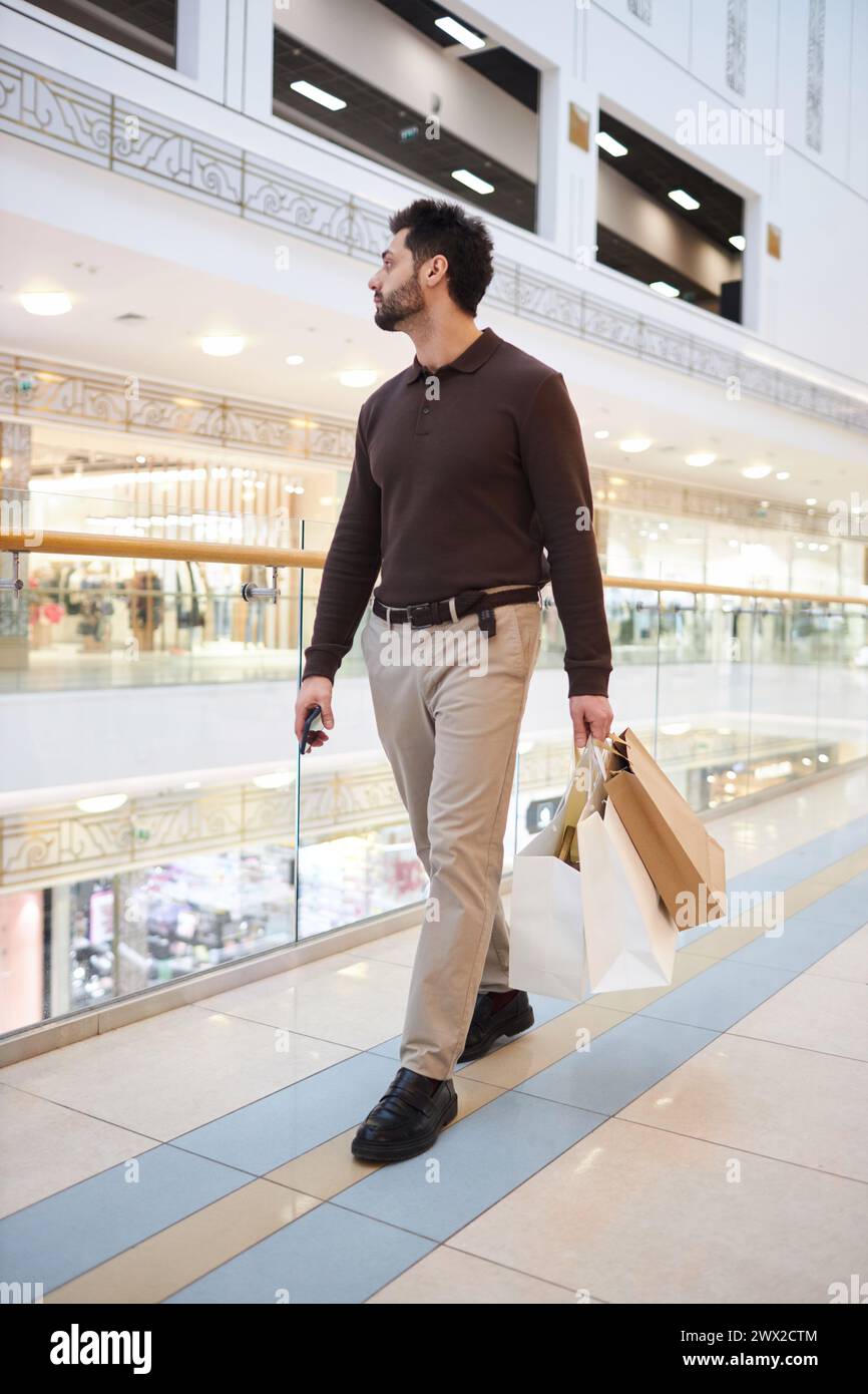 Vertical full length portrait of man walking in shopping mall and ...