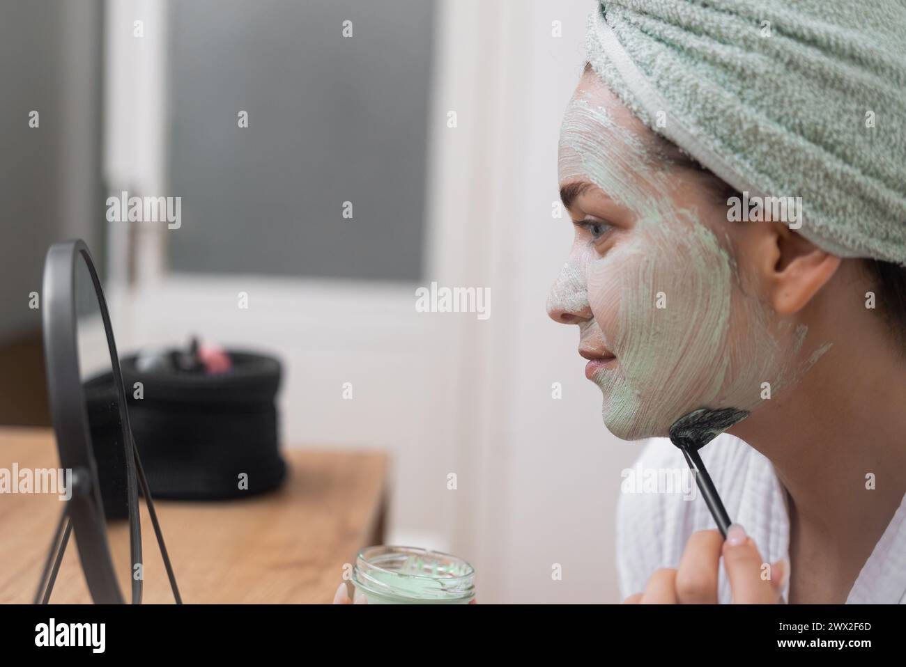 woman graces her face with a moisturizing mask, nurturing her skin's ...