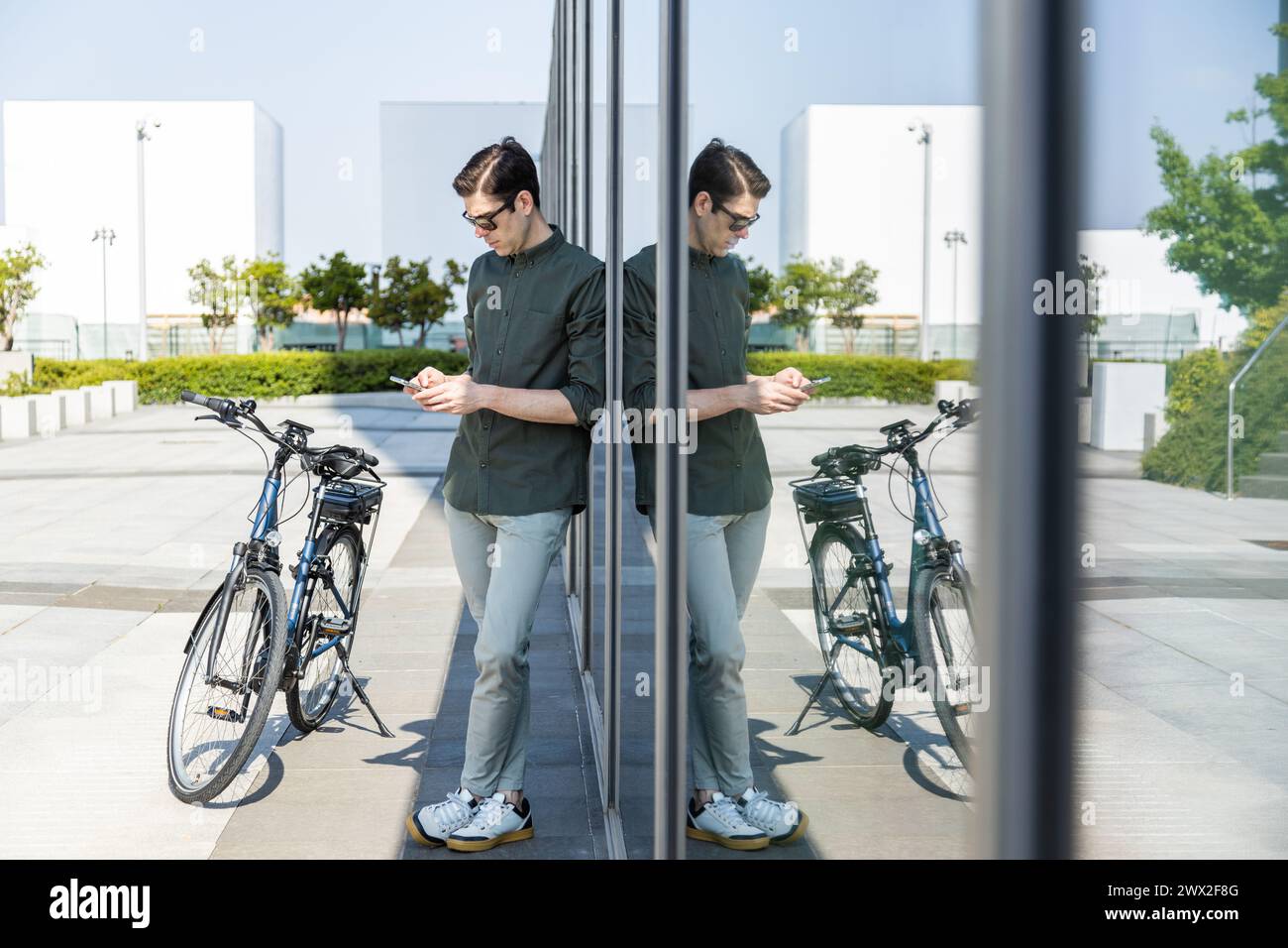 young businessman rides e-bike on his way to the tower where his office ...