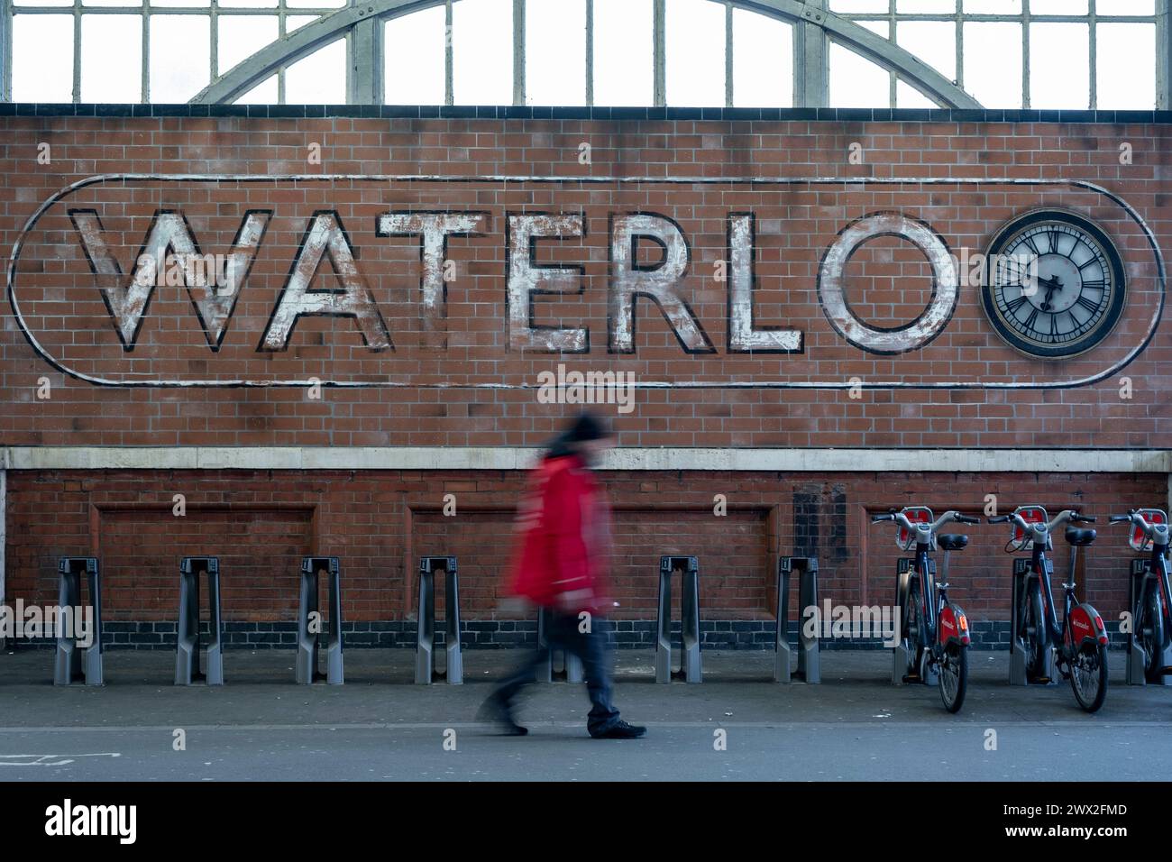 Faded sign for Waterloo Railway Station as people pass on 6th March ...