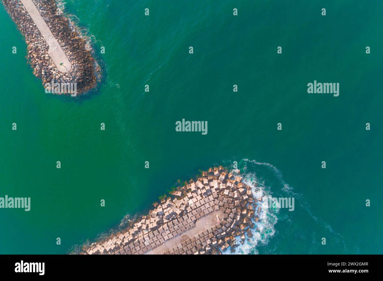 aerial overhead view of the breakwaters at the entrance of a harbor ...
