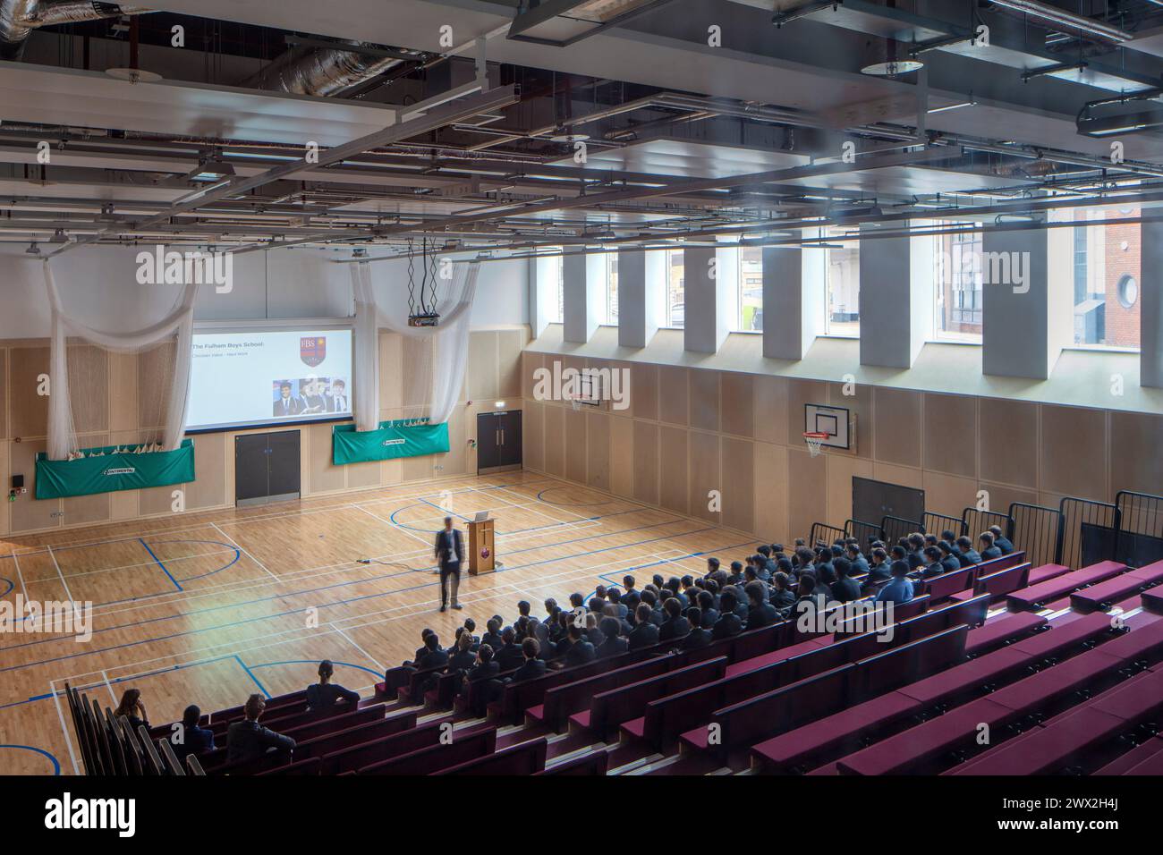 Main school hall with a teacher giving a speech. Fulham Boys School ...