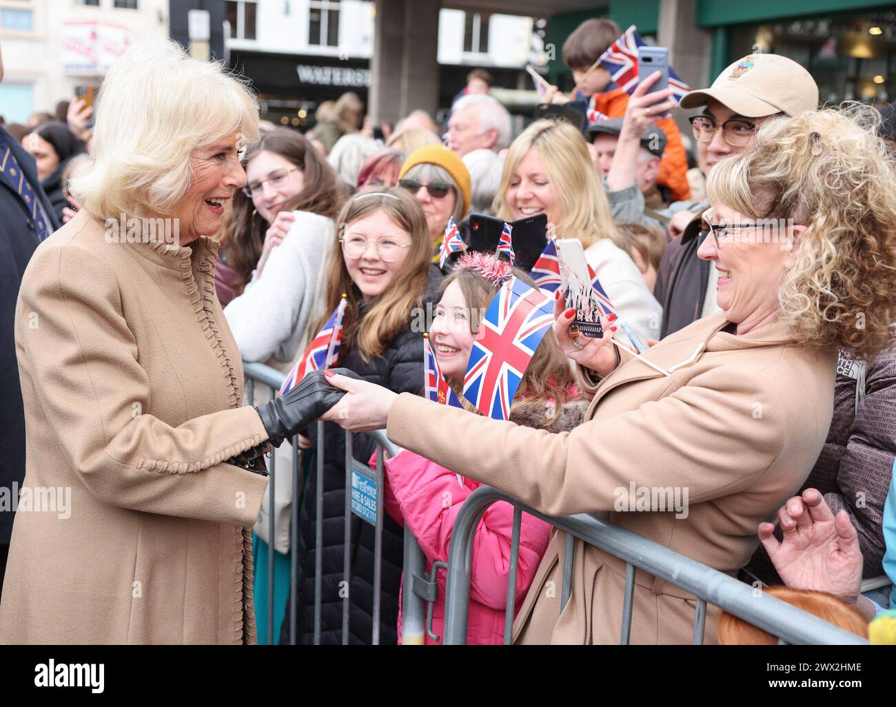 Queen Camilla smiles and shakes hands with well-wishers during a visit to the Farmers' Market in ...