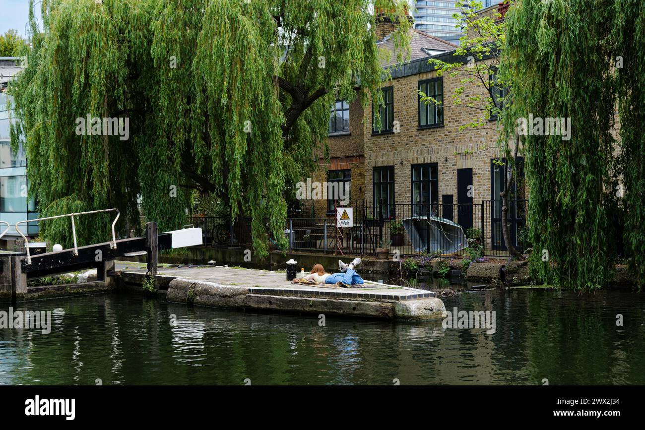 London - 06 03 2022: Girl lying reading on City Road Lock, Lock 5, on ...