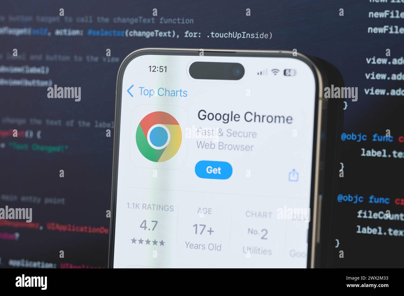 New York, USA - February 23, 2024: Google chrome on iphone screen in blurred code programming ...
