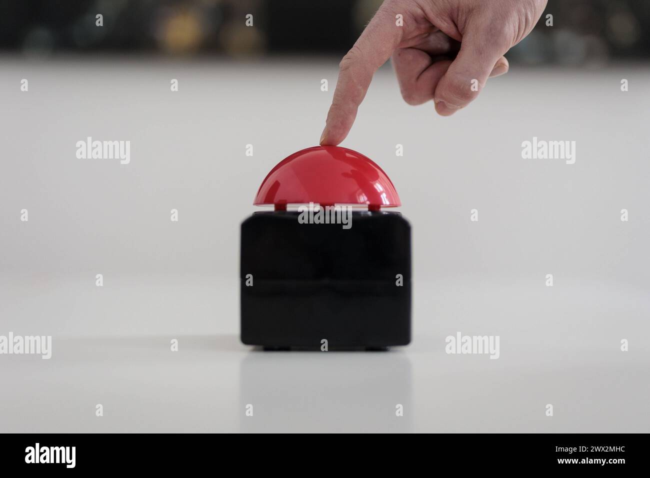 Ein Finger drueckt einen roten Buzzer-Button in Berlin, 27.03.2024 ...