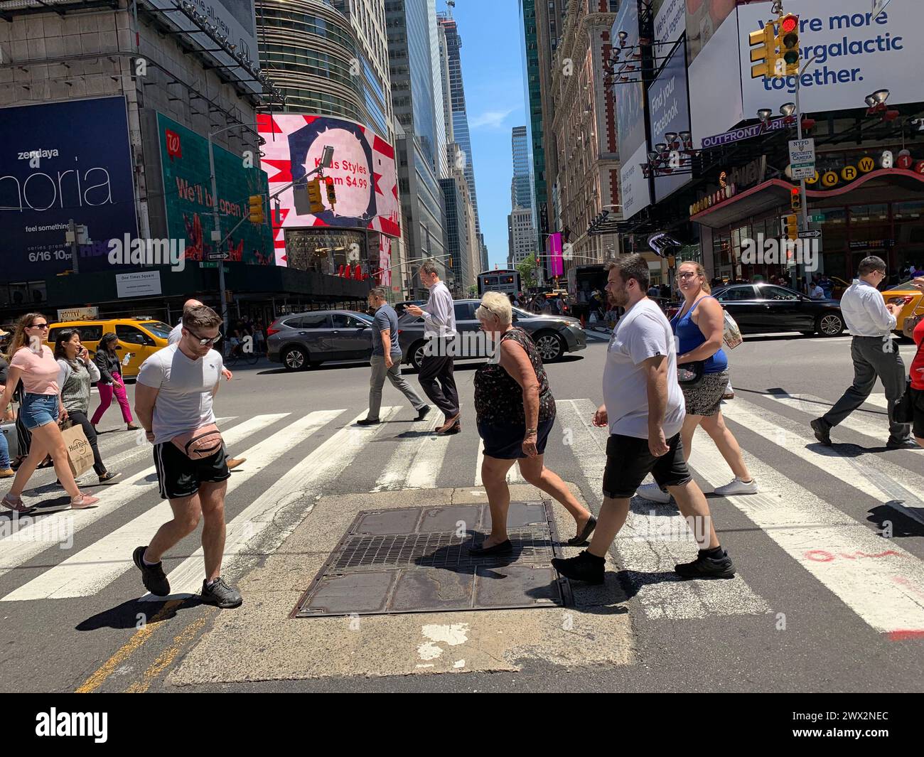 Pedestrians walk across the street in the crosswalk in New York’s Times ...