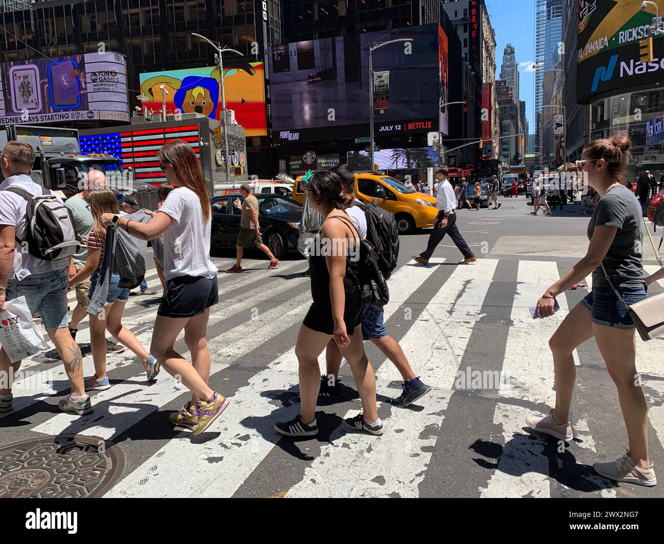 Pedestrians and travelers walk and cross the street using the crosswalk ...