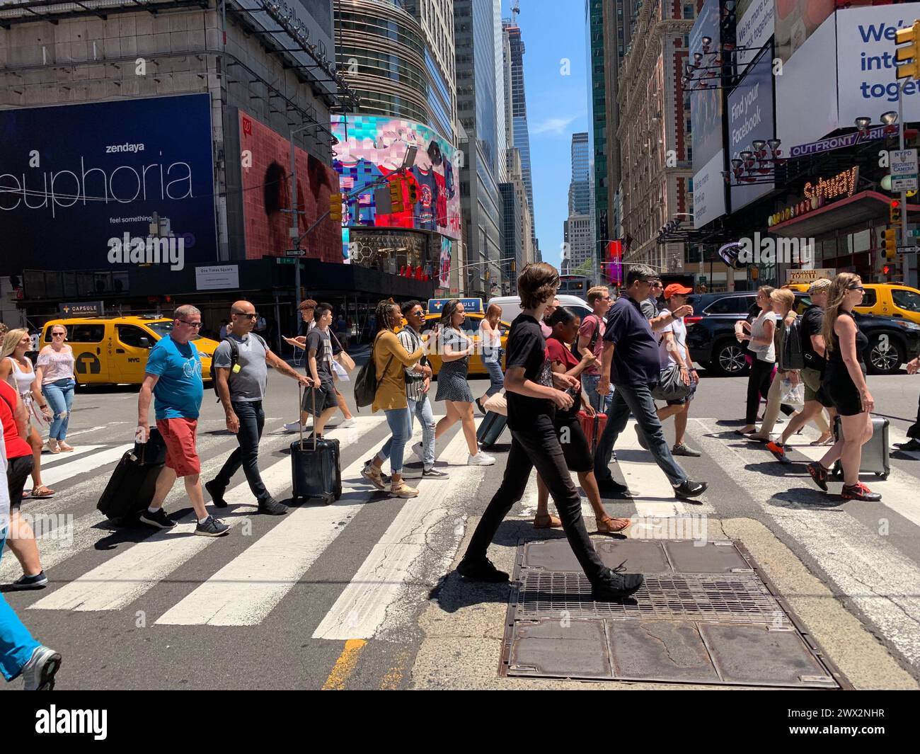 People make their way across the street, using the crosswalk in New ...