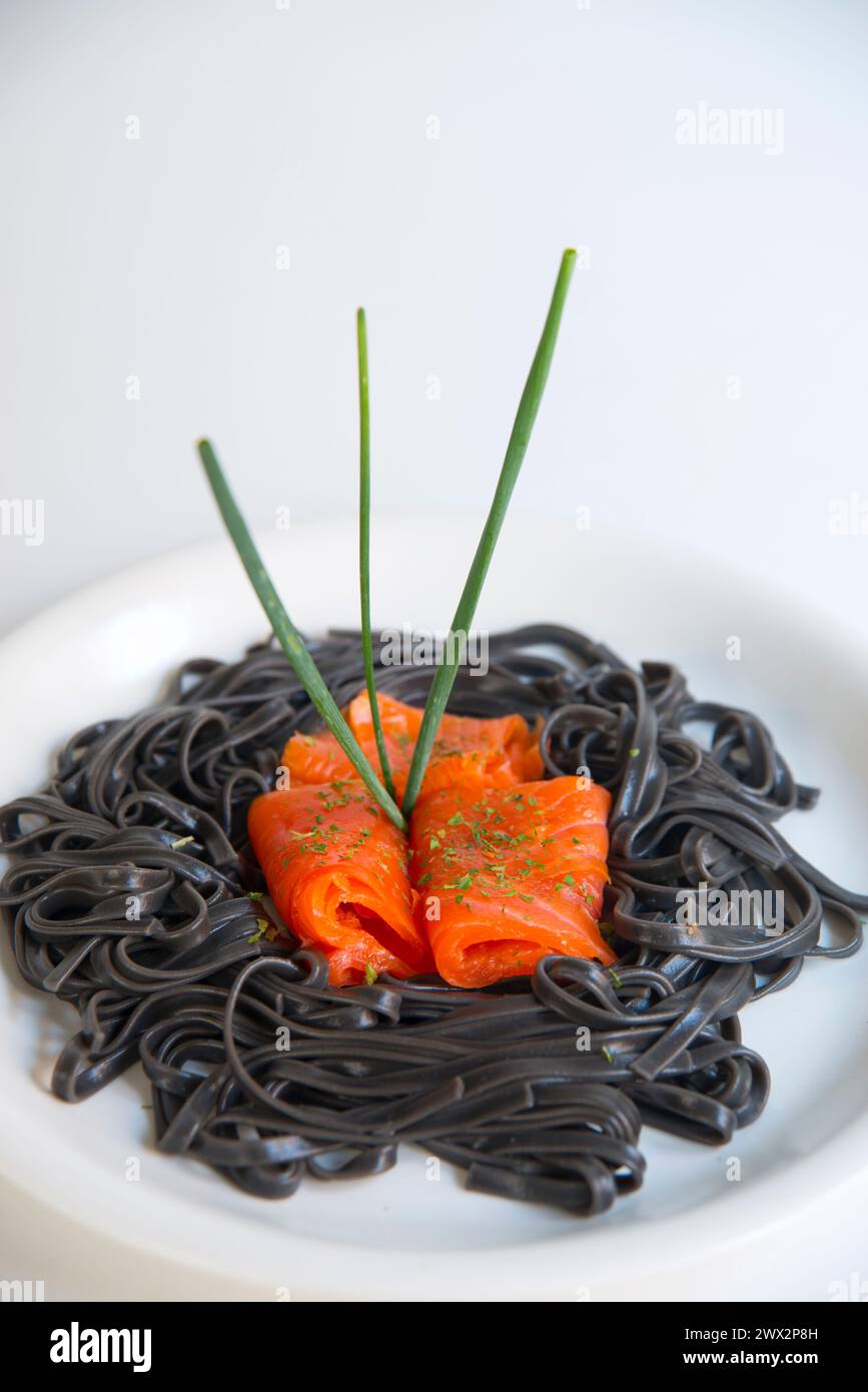 Black spaghetti with smoked salmon and chives Stock Photo - Alamy