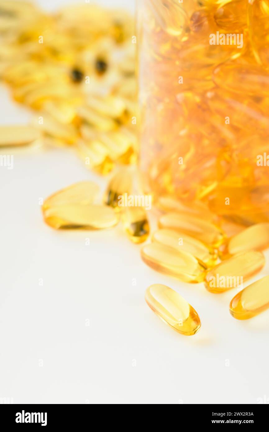 Close up capsules with Vitamin D, E or Omega 3,6,9 fatty acids in ...