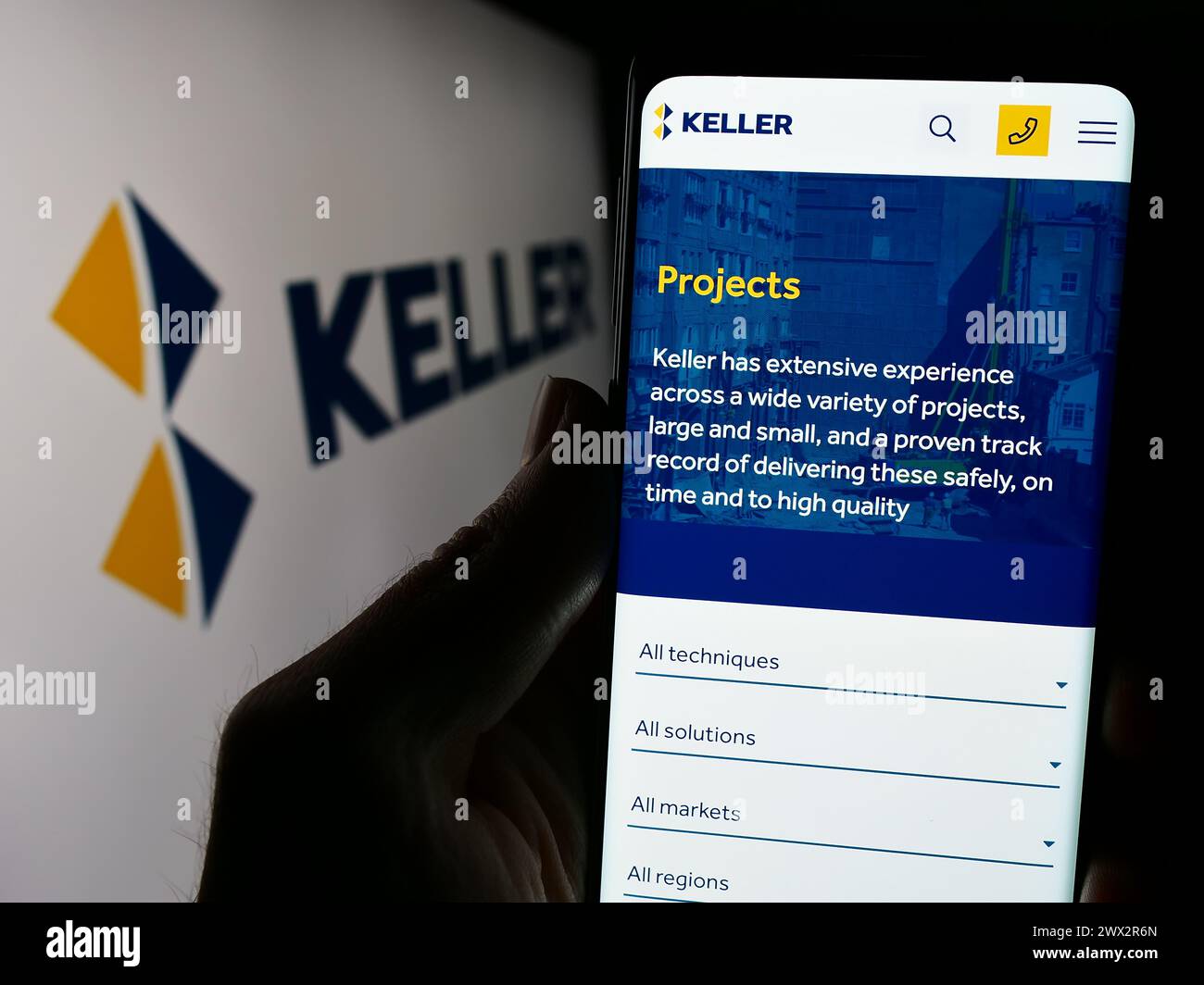 Person holding cellphone with webpage of geotechnical engineering company Keller Group plc in ...