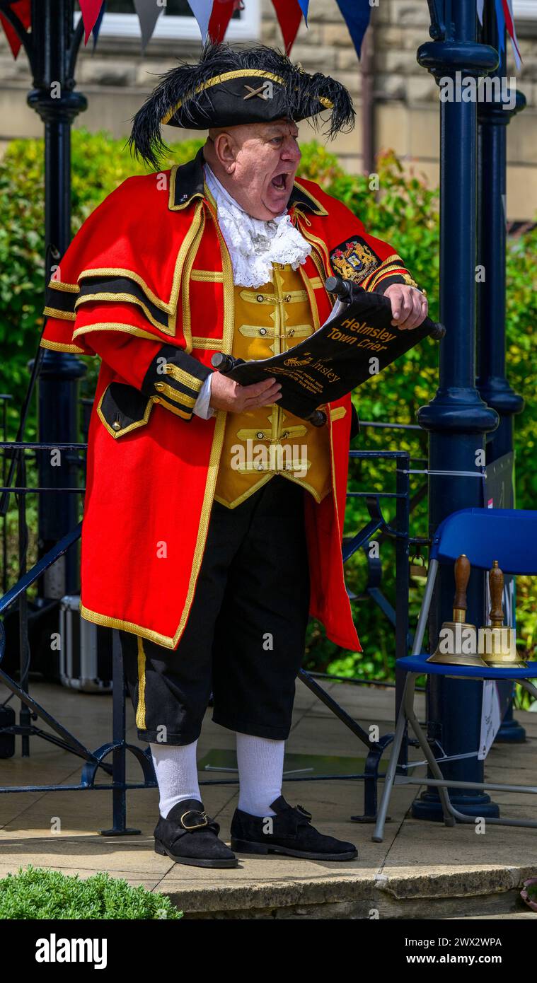 Male town crier (colourful crier's uniform, loud voice) proclaiming ...