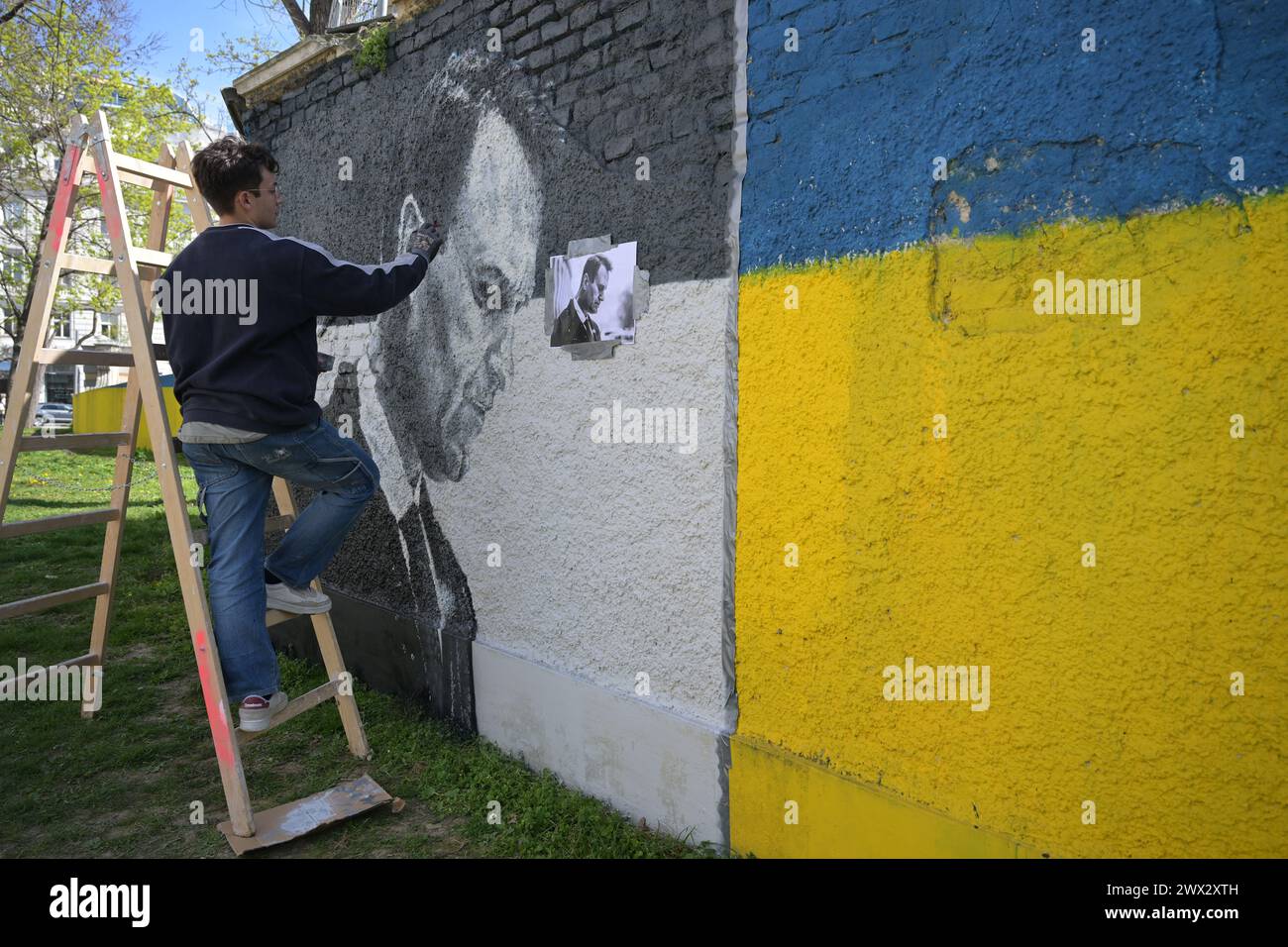 With two large portraits of Alexei Navalny on the wall behind the ...