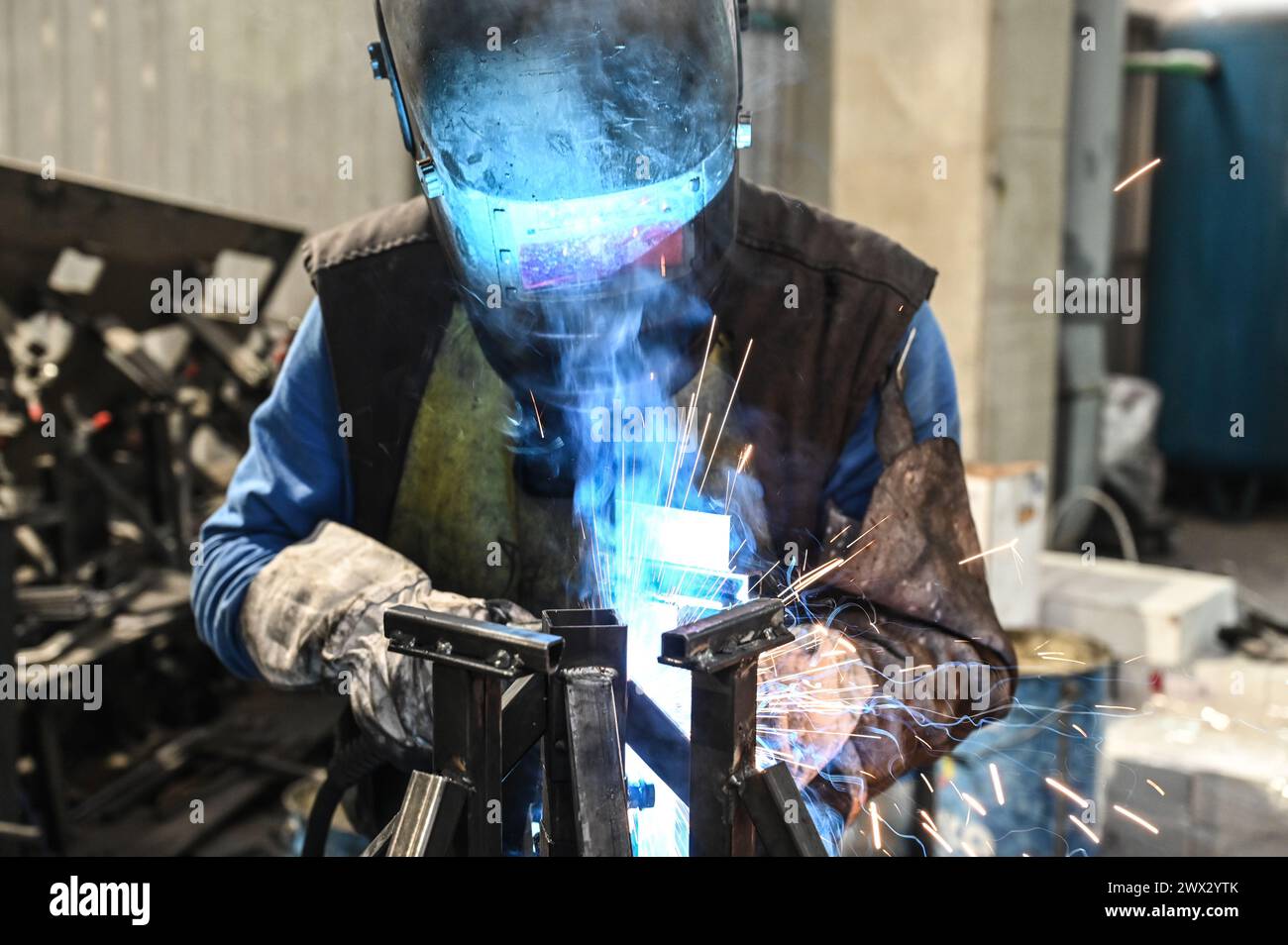 Welder at work. Welding sparkles. Male worker wearing helmet and gloves ...