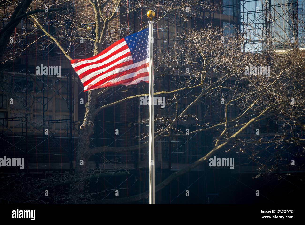 An American flag is whipped around by the wind outside of a school in ...