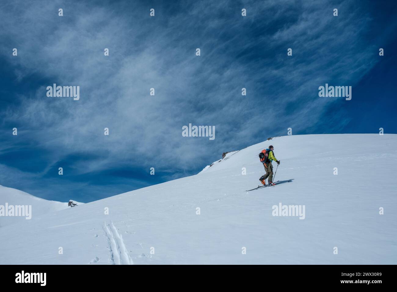 Skier ascending on fresh snow in Swiss Alps, backcountry, ski alpinist ...
