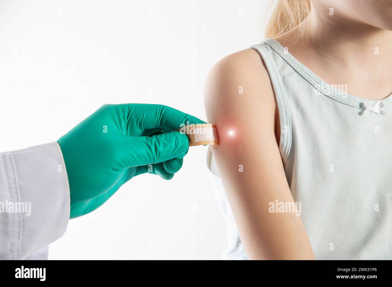 A doctor's hand in a green medical glove peels off a plaster from the ...