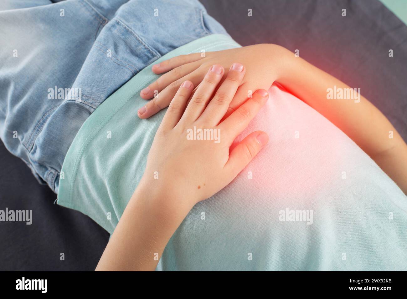 A little girl lies and holds her stomach, which hurts. Concept of ...