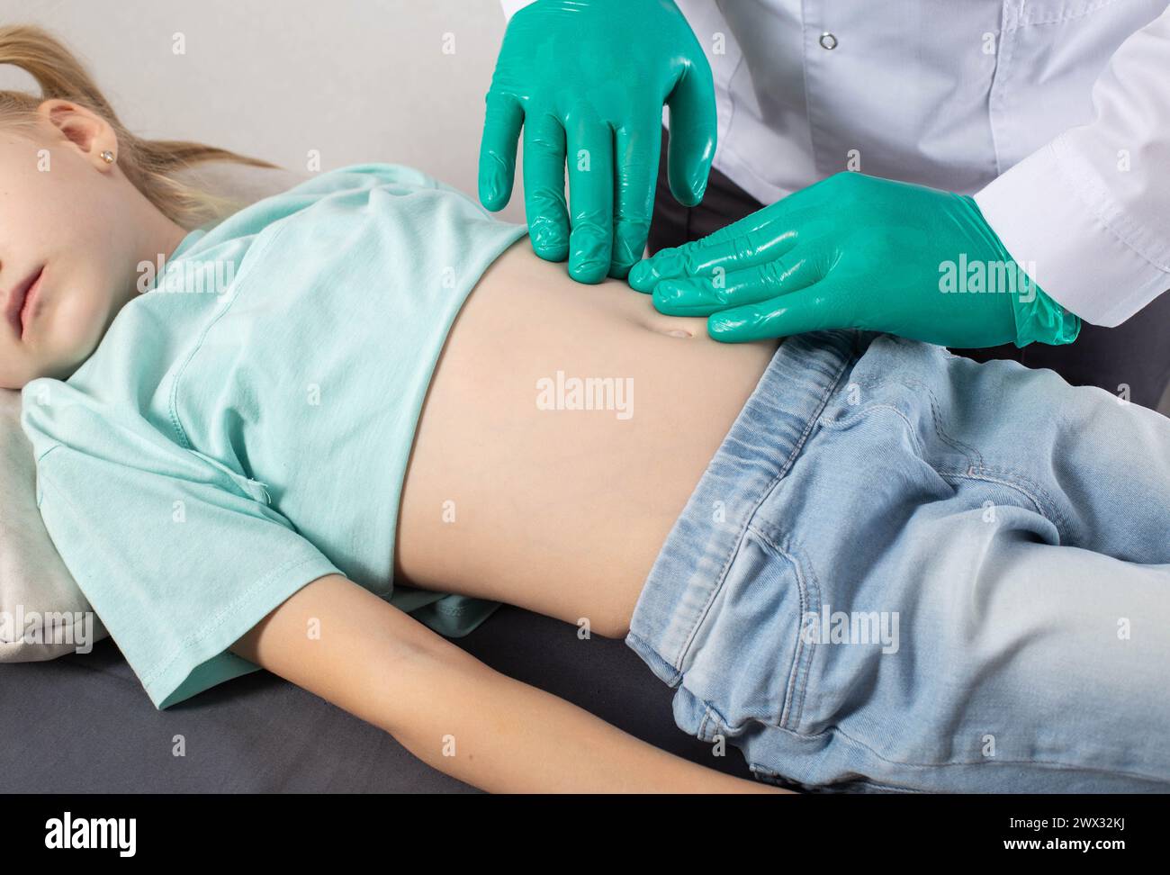 A gastroenterologist palpates the abdomen of a seven-year-old little ...