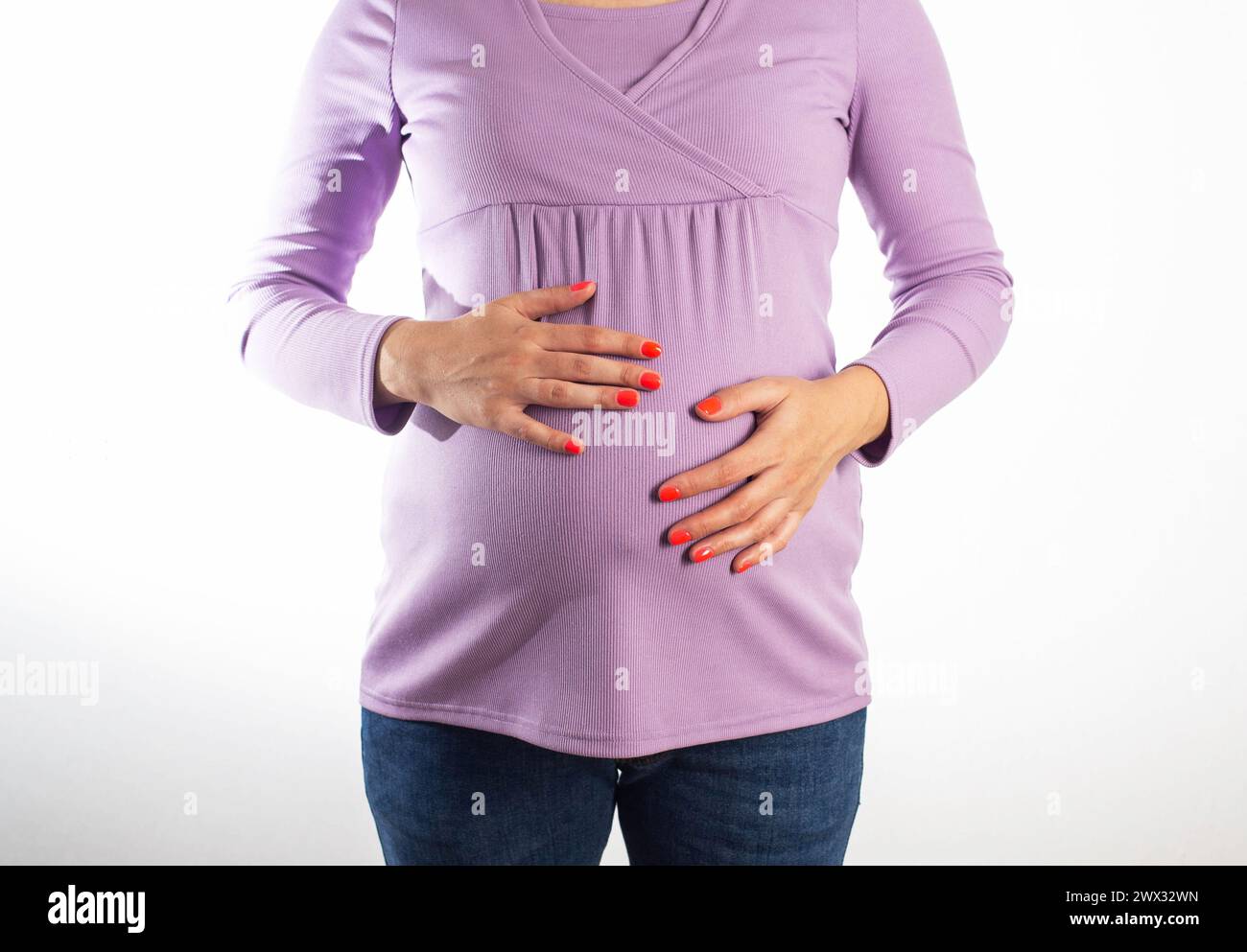 A pregnant girl with a purple sweater holds her swollen belly. Concept ...