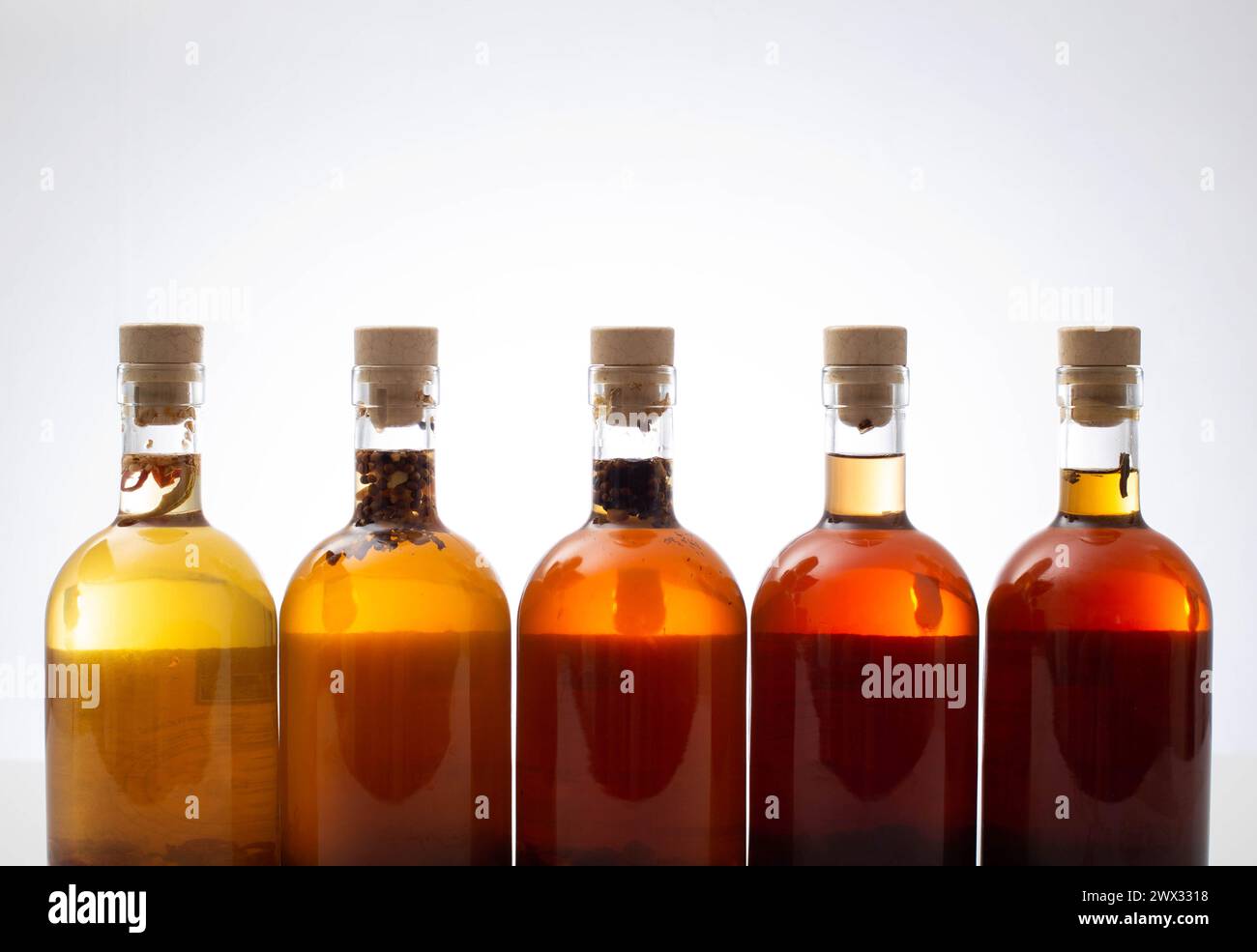 Transparent bottles with brown alcoholic drink on a white background ...