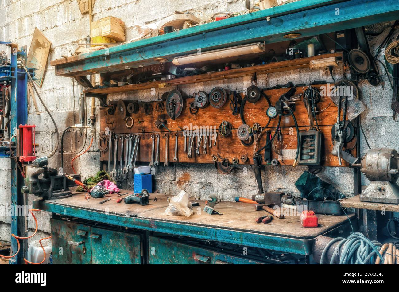 Vintage workshop. Antique tools hang on wall, repair equipment on the ...