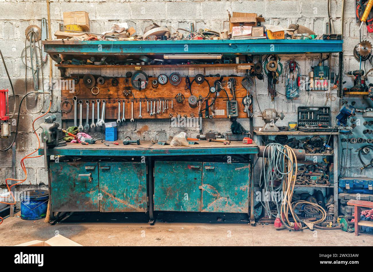 Vintage workshop. Antique tools hang on the wall, repair equipment on ...